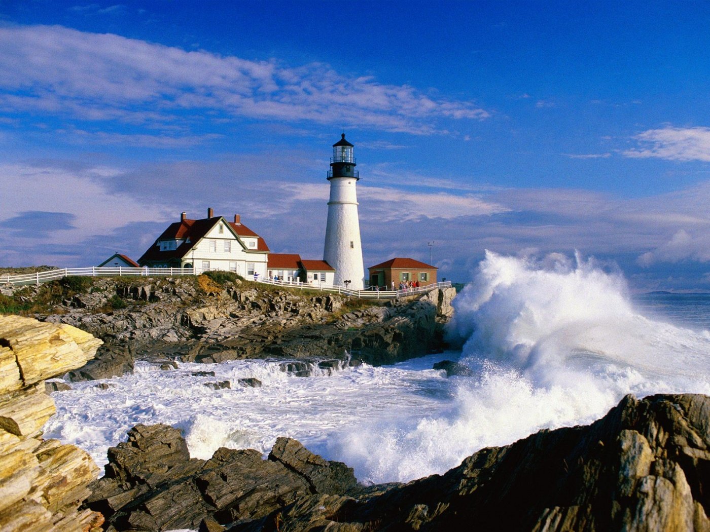 Stunning HD Lighthouse Over Rocky Shoreline Amid Crashing Waves