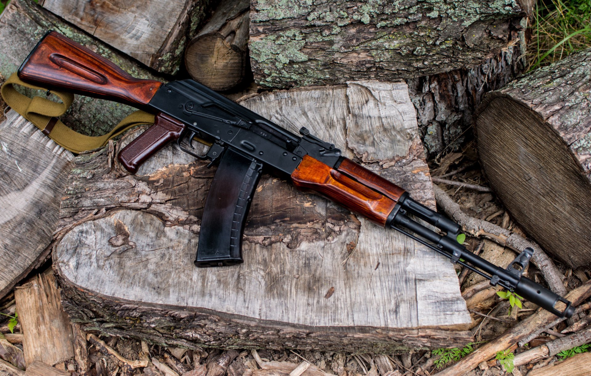 HD Wallpaper of a Classic AK-47 on Natural Logs