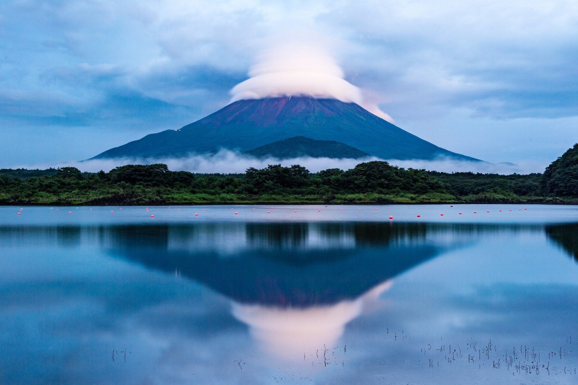 Majestic Mount Fuji: Serene Lake Reflection Amidst Smoky Peaks of Japan